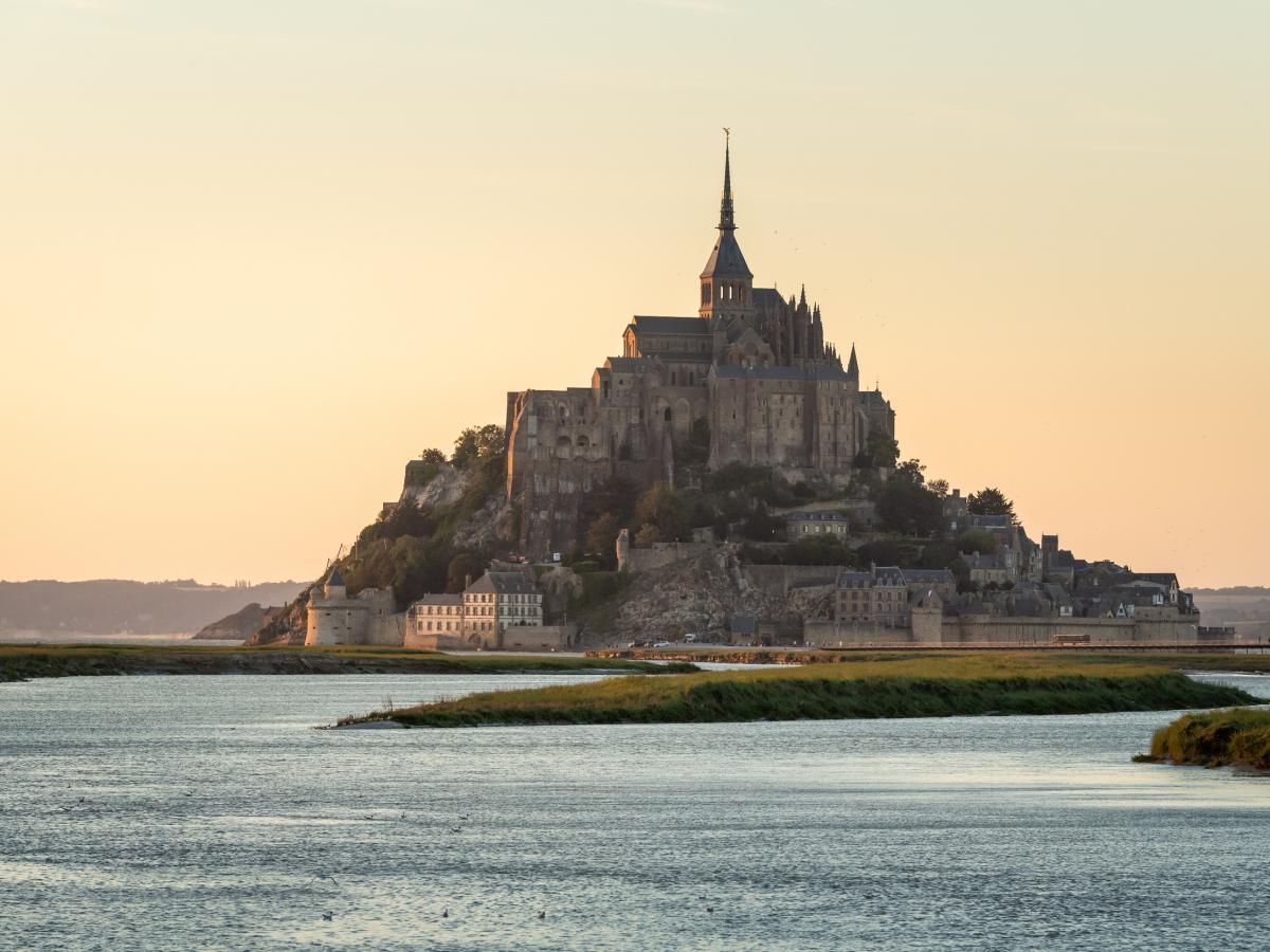 © Vue sur le Mont-Saint-Michel en fin de journee au coucher du soleil ...